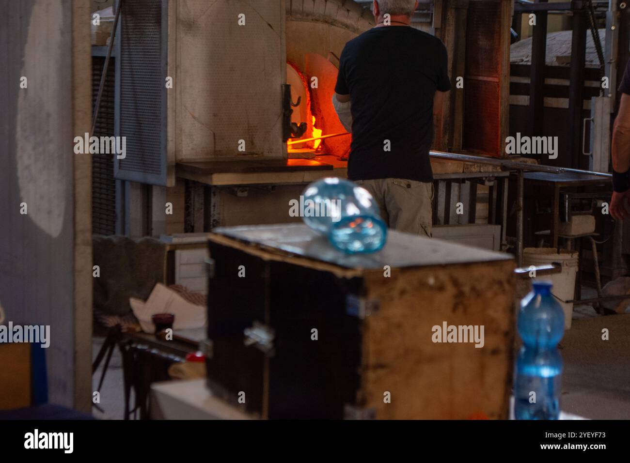 Murano glass-blowing factory. blower forming beautiful piece of glass ...