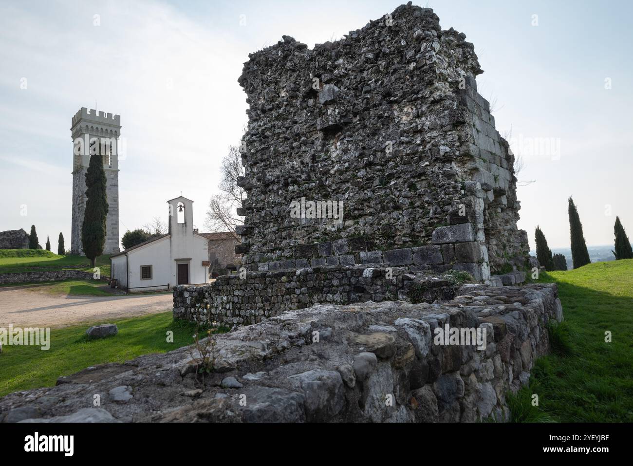 The ruins of a tower in the castle of Fagagna with the church behind ...
