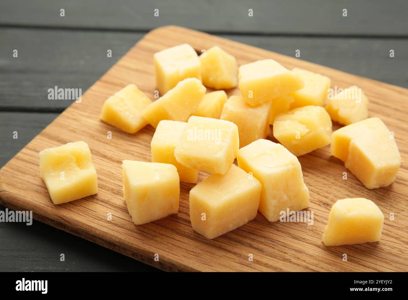 Cheese cubes on cutting board on black background. Parmesan. Top view ...