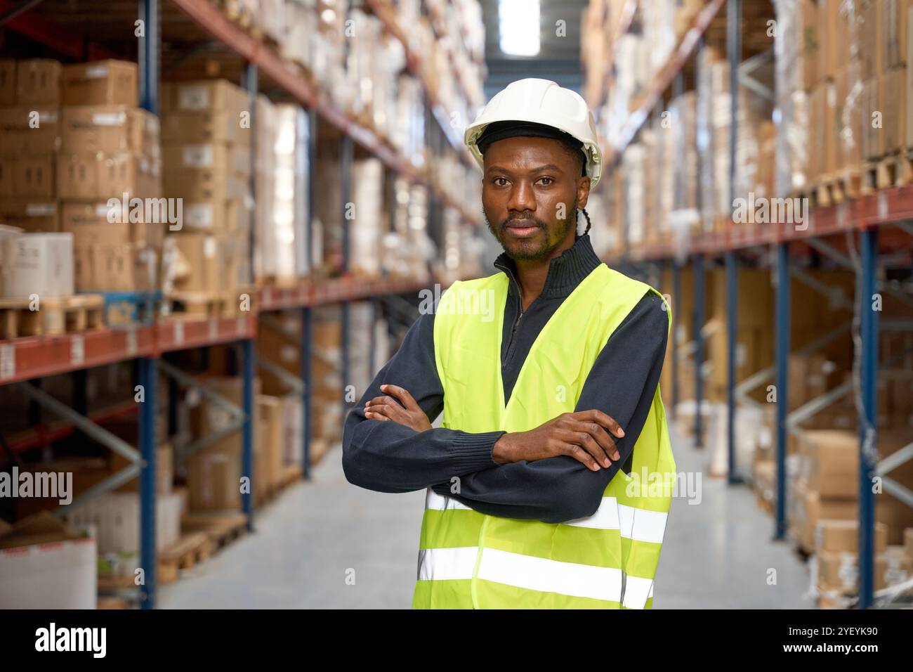 Warehouse worker crossing arms in logistics center Stock Photo - Alamy