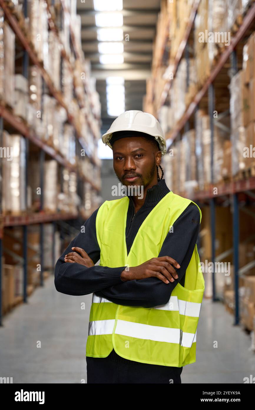 Confident logistics worker posing with crossed arms in warehouse Stock ...