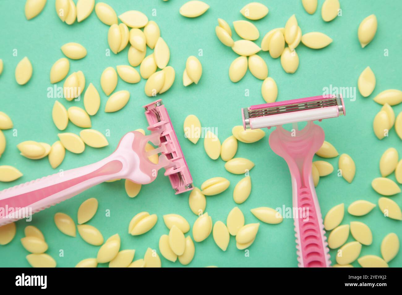 Wax granules for depilation with a razor on mint background. Space for ...