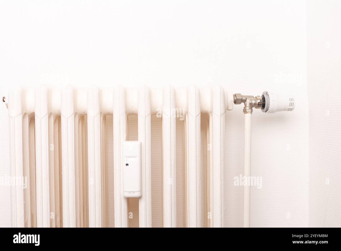 White radiator thermostat valve on light wite background, minimal home ...