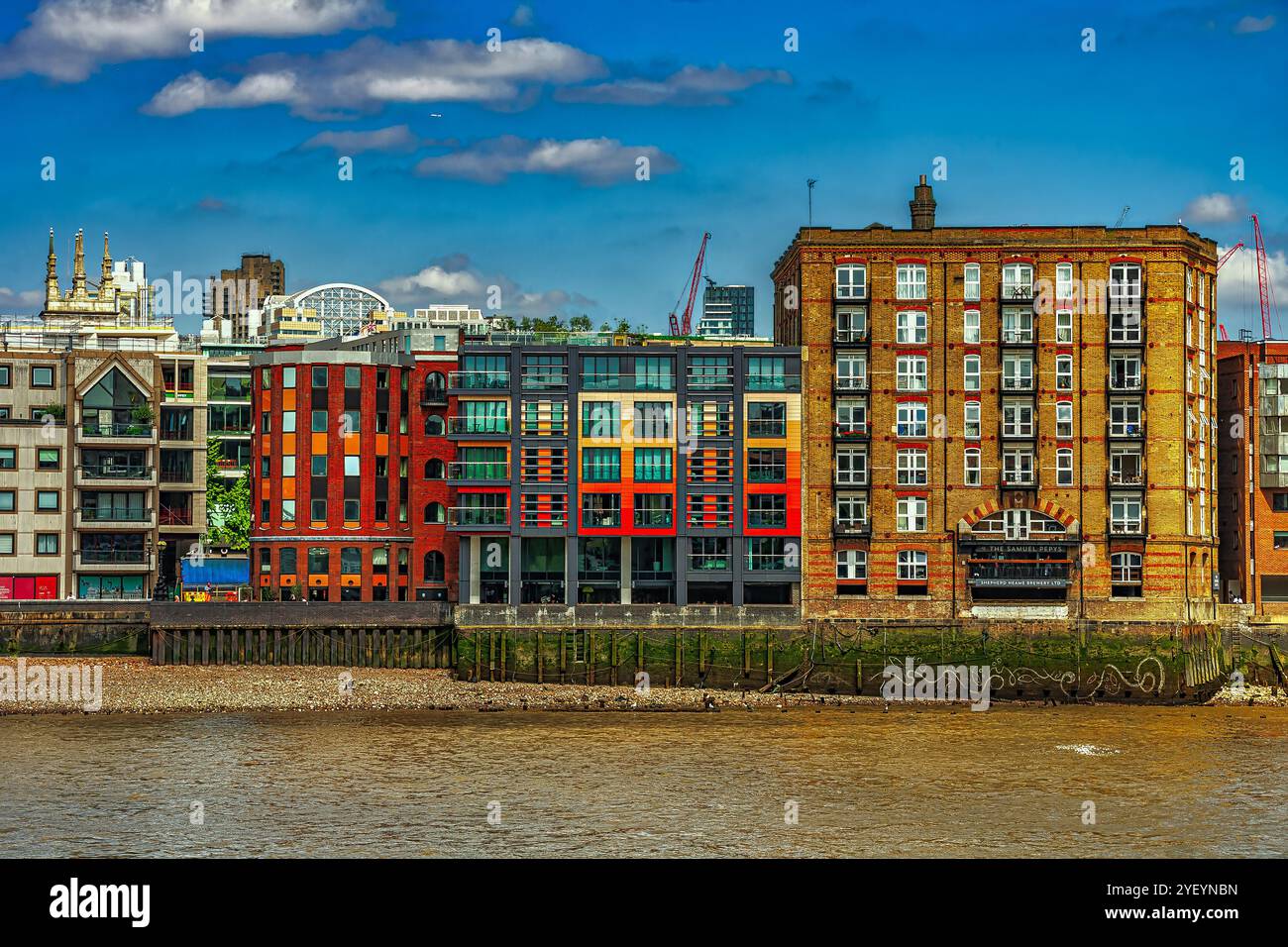 Colorful modern and old buildings overlook the banks of the Thames ...