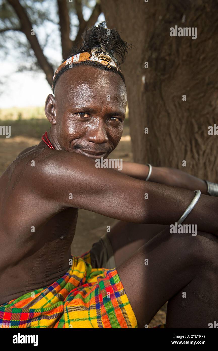 Young man with traditional head bun and scarification typical for ...