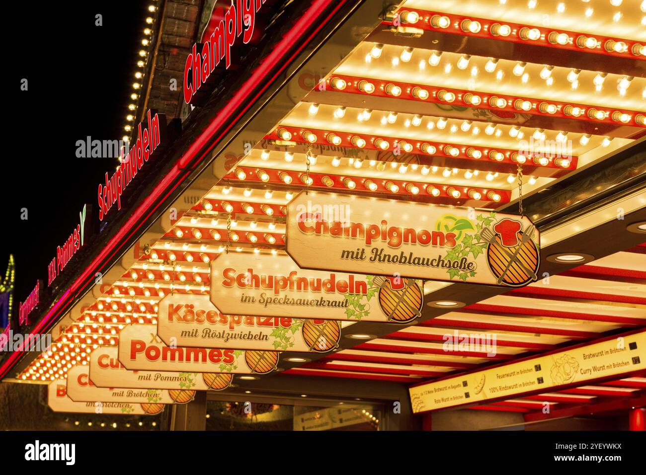 Illuminated market scene at night with signs for food: Mushrooms and ...