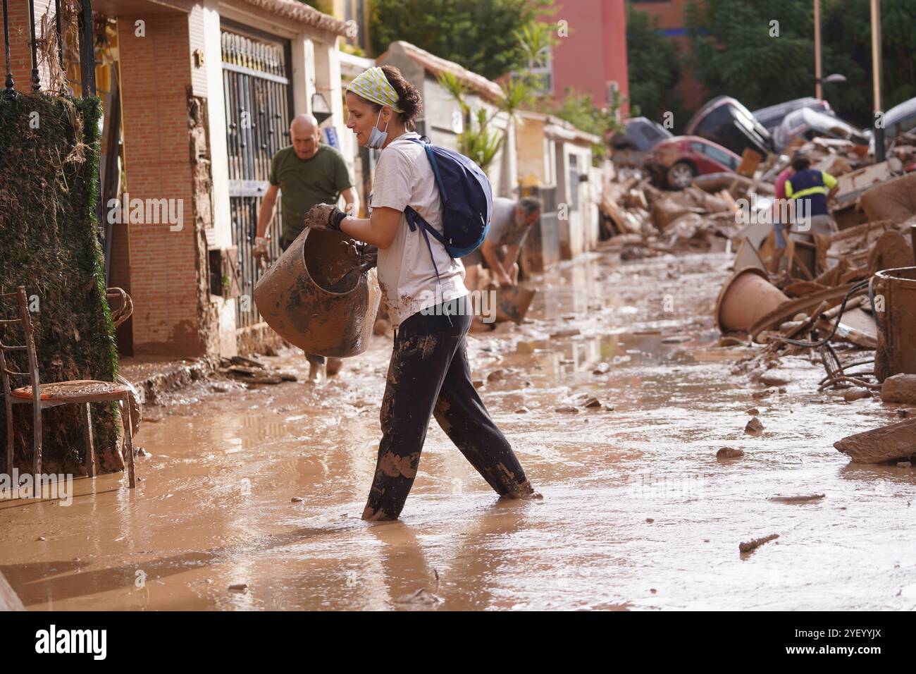 A volunteer walks in the mud while helping with the clean up operation ...