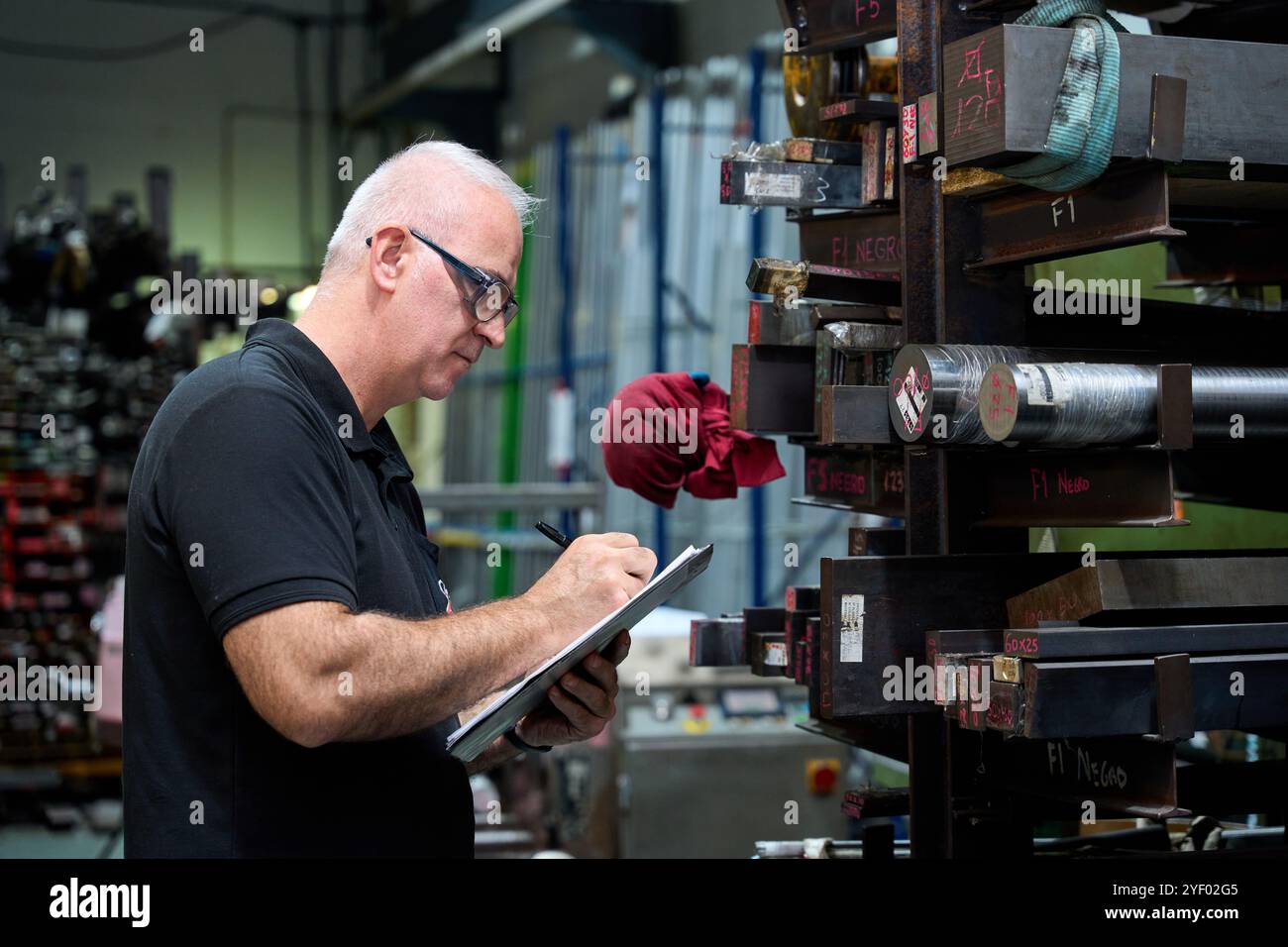 Metalworker measuring custom mechanical parts in metallurgy fabric ...