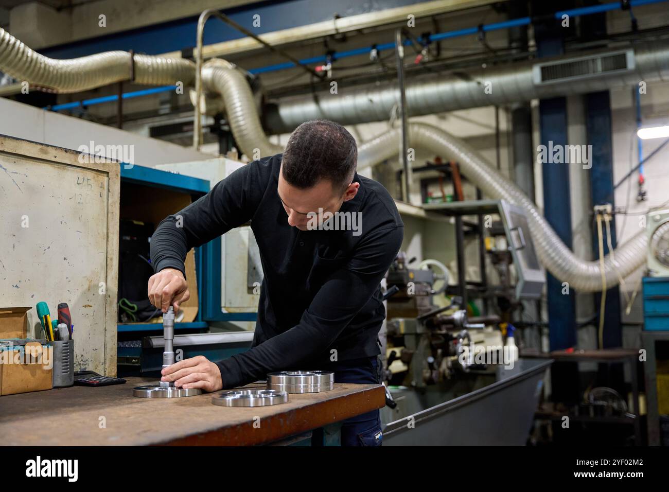 Metalworker operating cnc machine in manufacturing plant Stock Photo ...