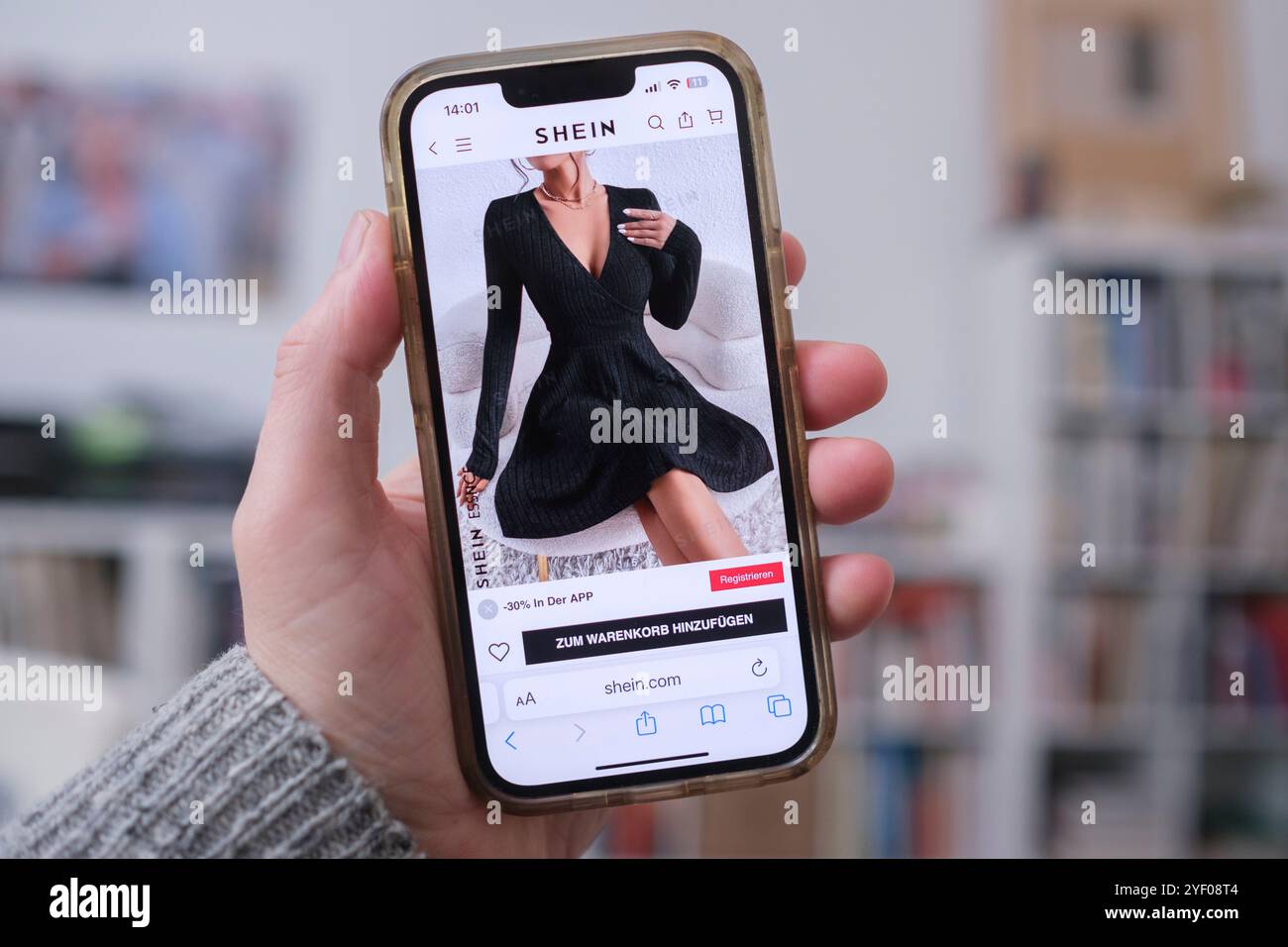 Hand holding a mobile phone showing the website of the Chinese company ...