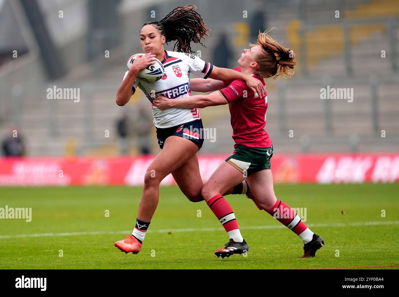 England's Amelia Brown is tackled by Wales' Dani McGifford, during the ...