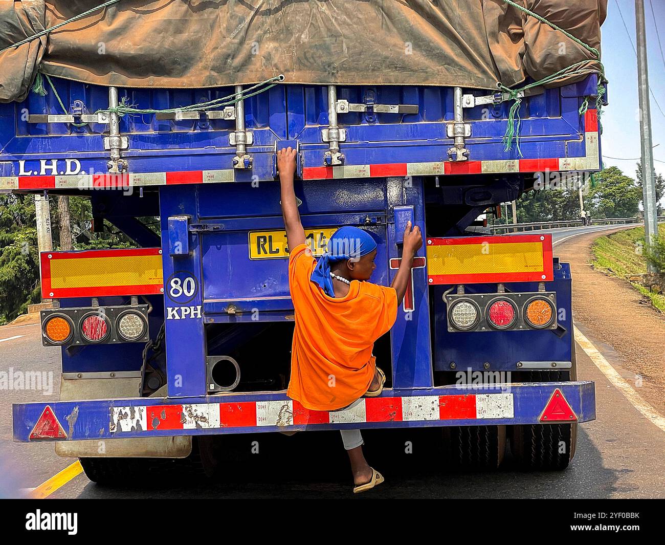 Boy traveling on the back of a truck in Rwanda Stock Photo - Alamy