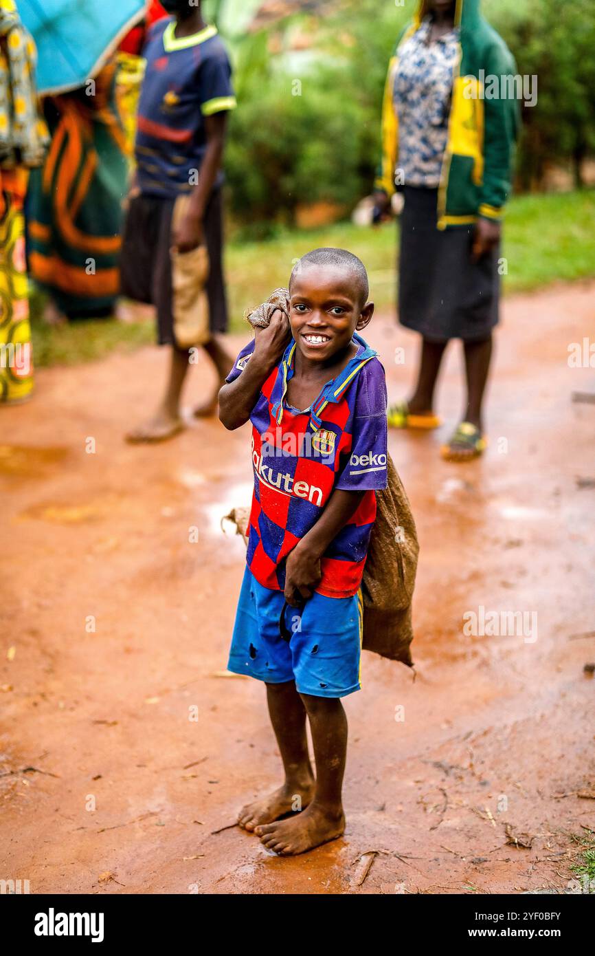 Shivering boy standing on a road after a shower in southern Rwanda ...
