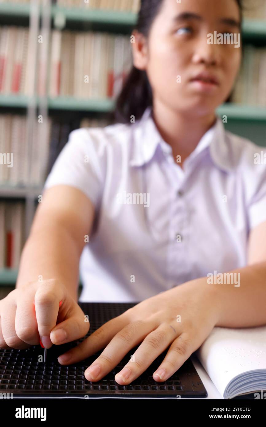 Center for blind children. Blind girl reading braille book Ho Chi Minh ...