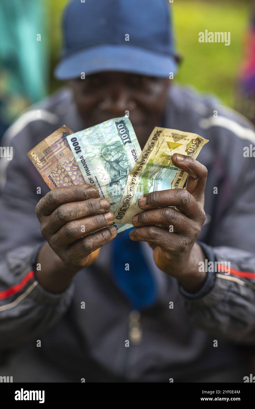 Microfinance borrower holding bank notes in a village near Huye ...