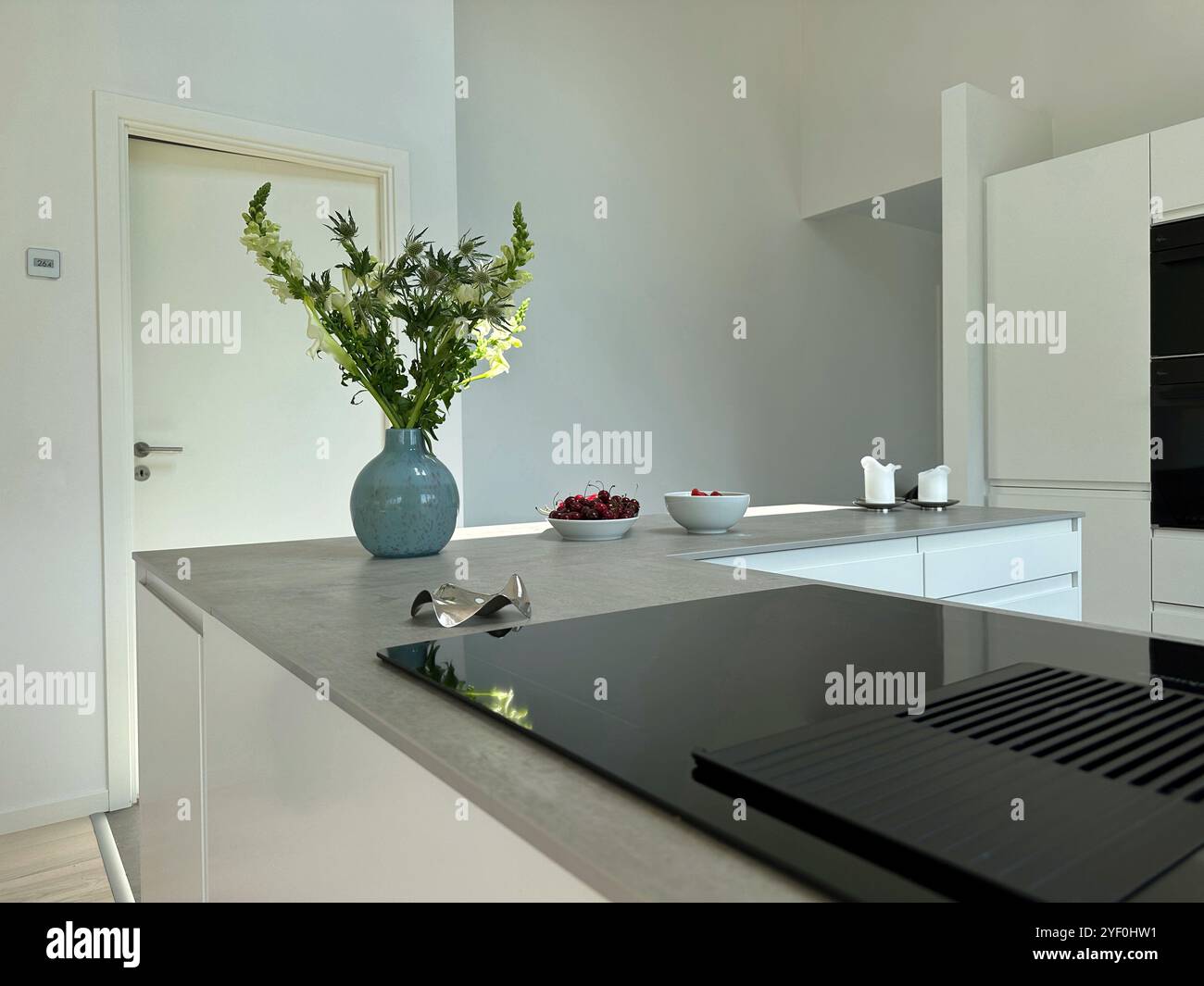 Stylish open plan kitchen with a cooker and an integrated extractor fan ...