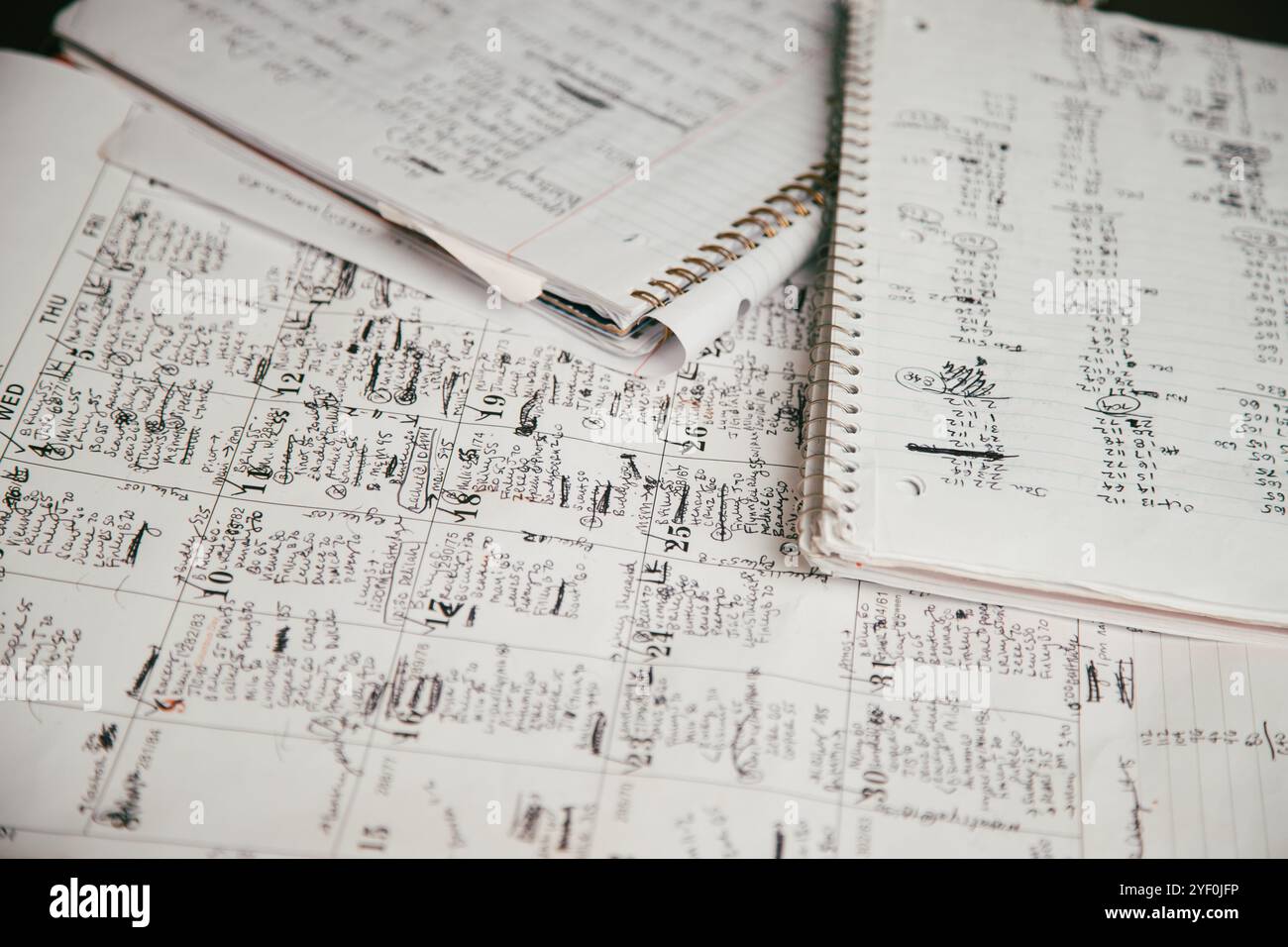Close-up of notebooks and paperwork with schedules, diary and financial ...