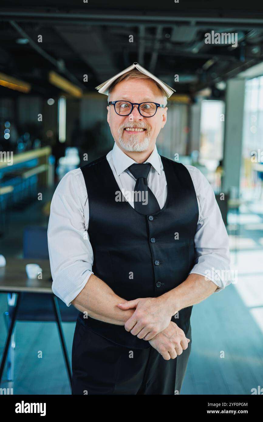 Emotional old man in glasses with a notebook in the office. An old ...