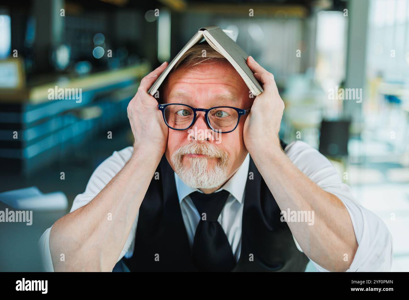 Emotional old man in glasses with a notebook in the office. An old ...