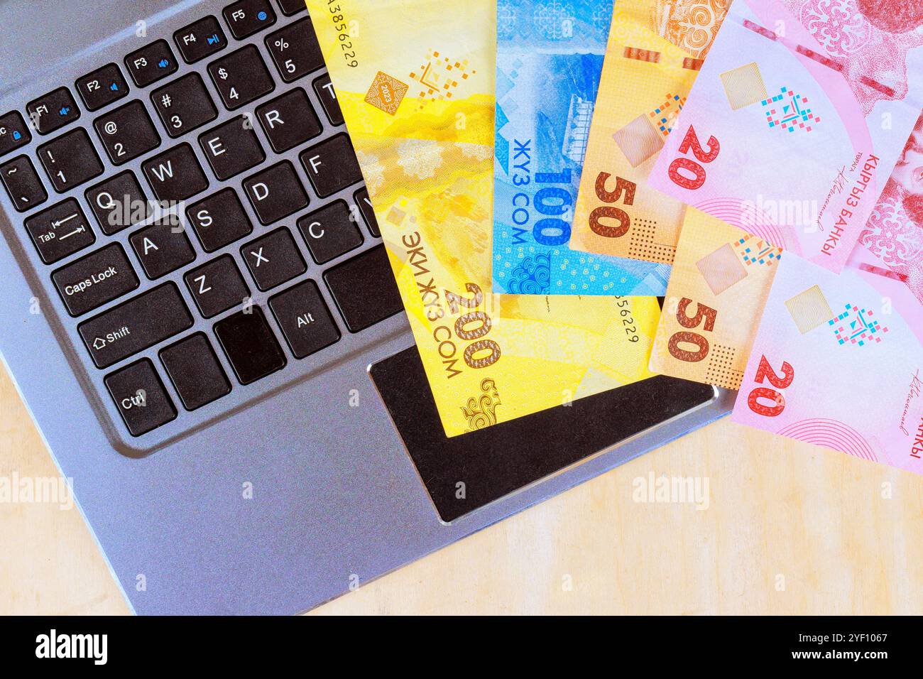 Kyrgyzstan money som various banknotes over keyboard to online payment ...