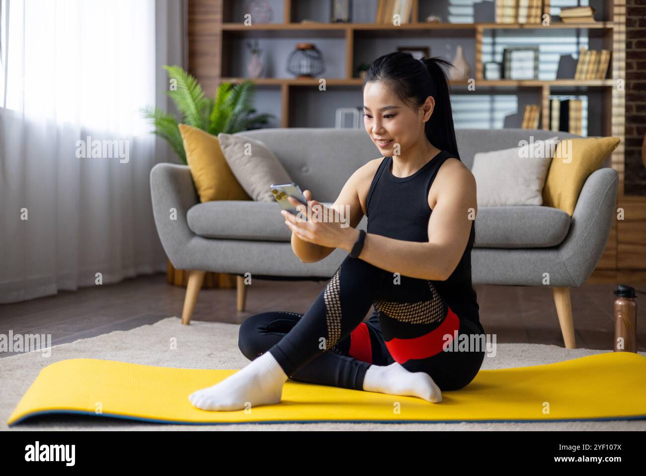 Woman smiles using smartphone home hi-res stock photography and images ...