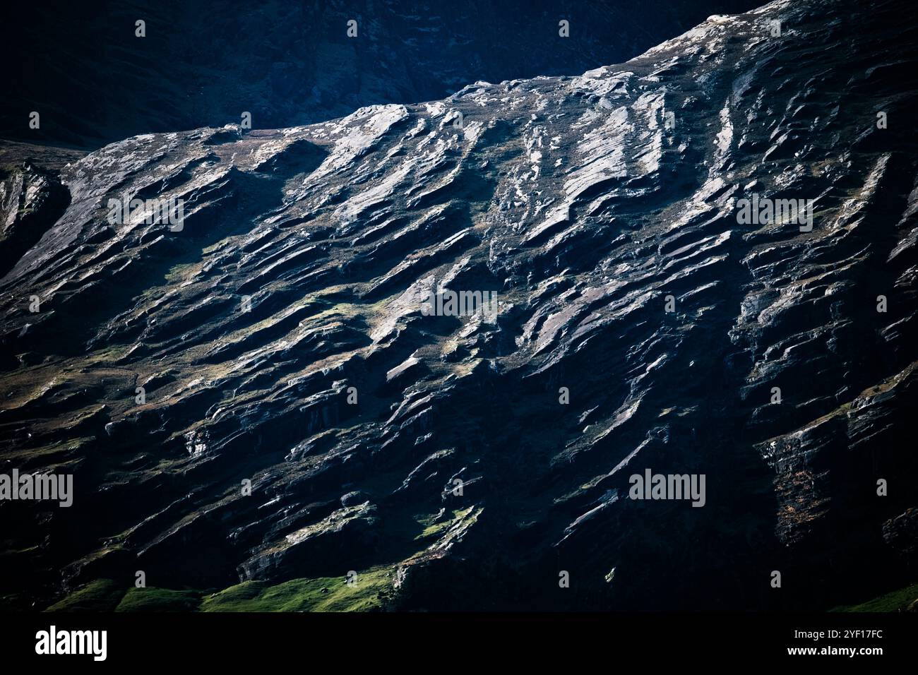 The rugged terrain features striking layered rock formations ...