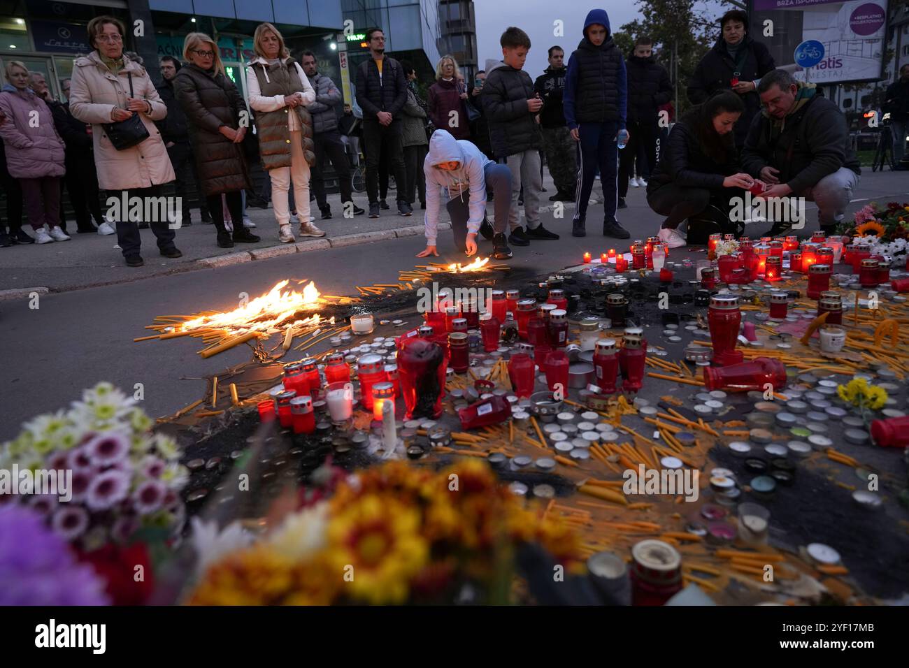 People light candles for the victims of an outdoor roof collapse at a ...
