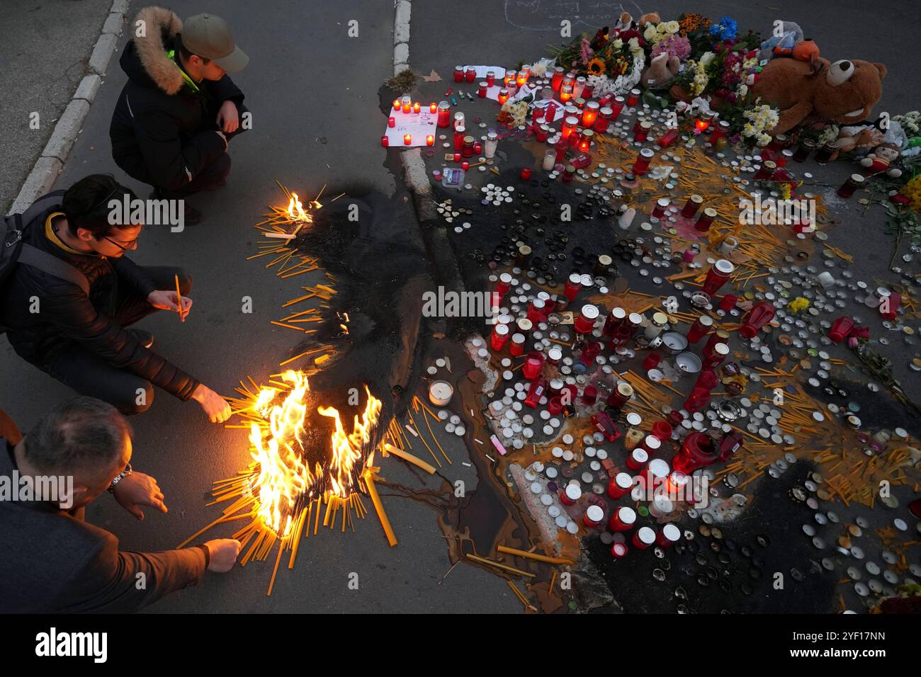 People light candles for the victims of an outdoor roof collapse at a ...