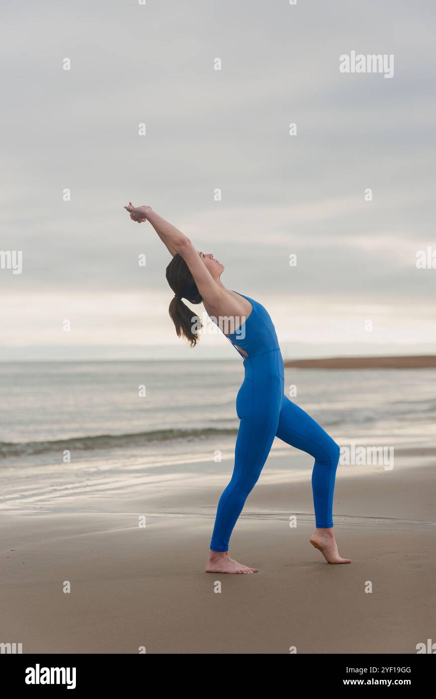 sporty woman doing a backbend yoga stretching exercise outdoors at the ...