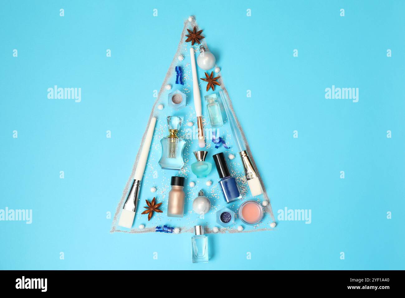 Christmas tree made of perfume bottles and makeup products on light ...