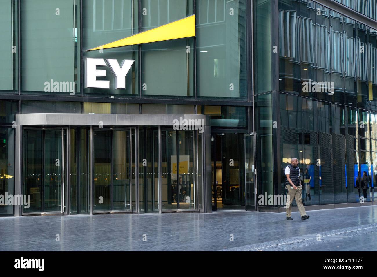 A man walks pass the entrance to Financial services firms EY office ...