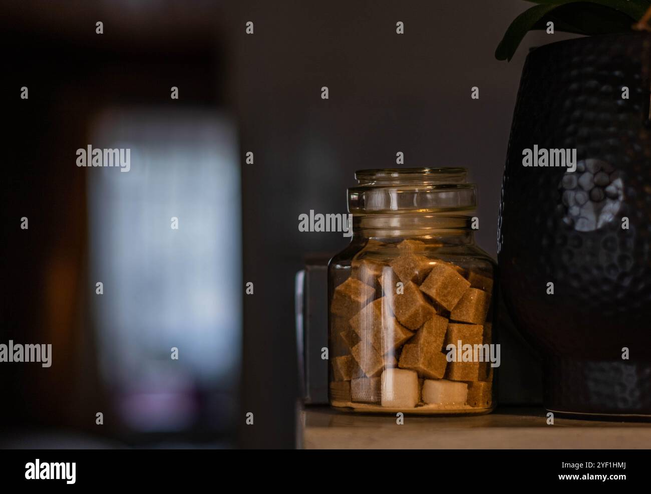 Brown sugar cubes in a jar at orange room light Stock Photo - Alamy