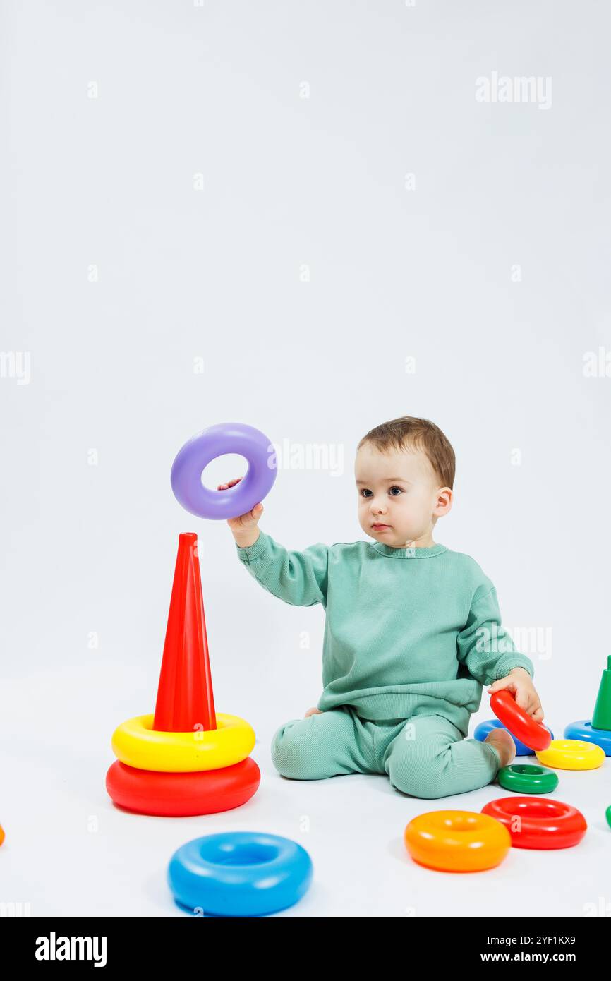 Little boy playing logic educational games with plastic pyramid ...