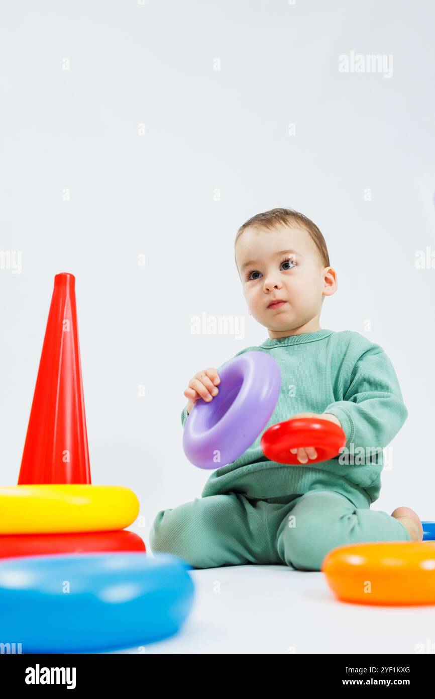 Little boy playing logic educational games with plastic pyramid ...
