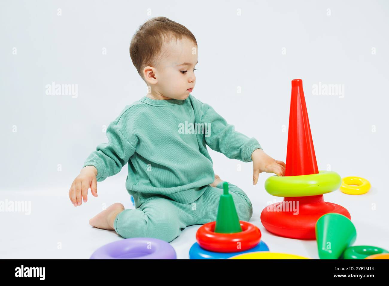 Little boy playing logic educational games with plastic pyramid ...