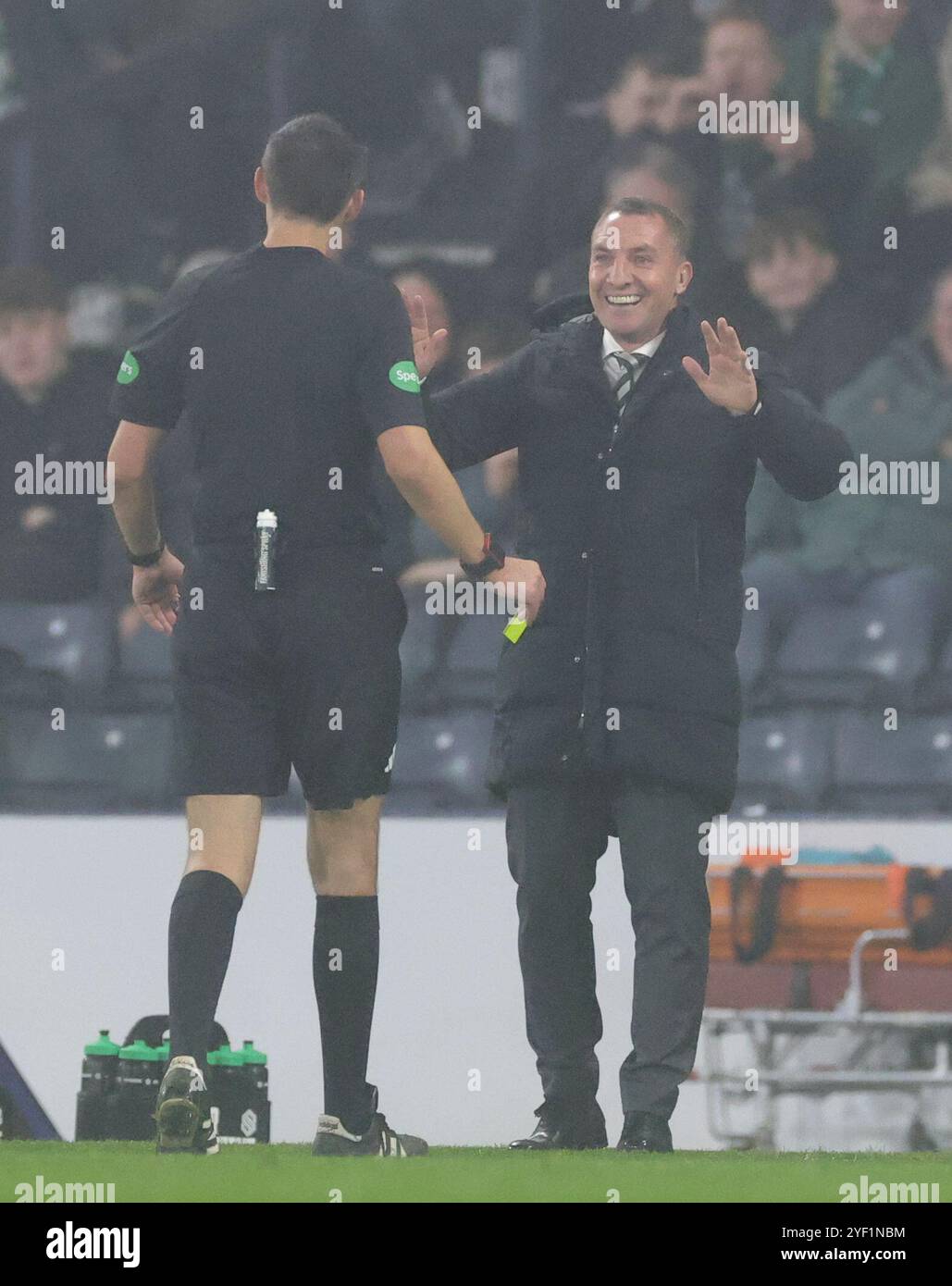 Celtic manager Brendan Rodgers (right) is shown a yellow card by ...
