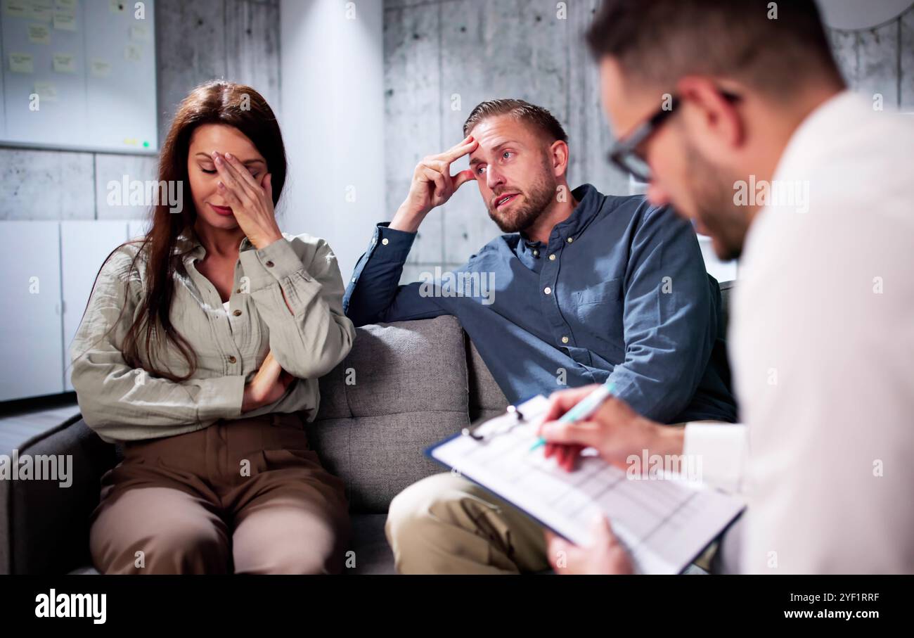 Sad Young Couple Sitting On Sofa With Female Psychologist Stock Photo ...