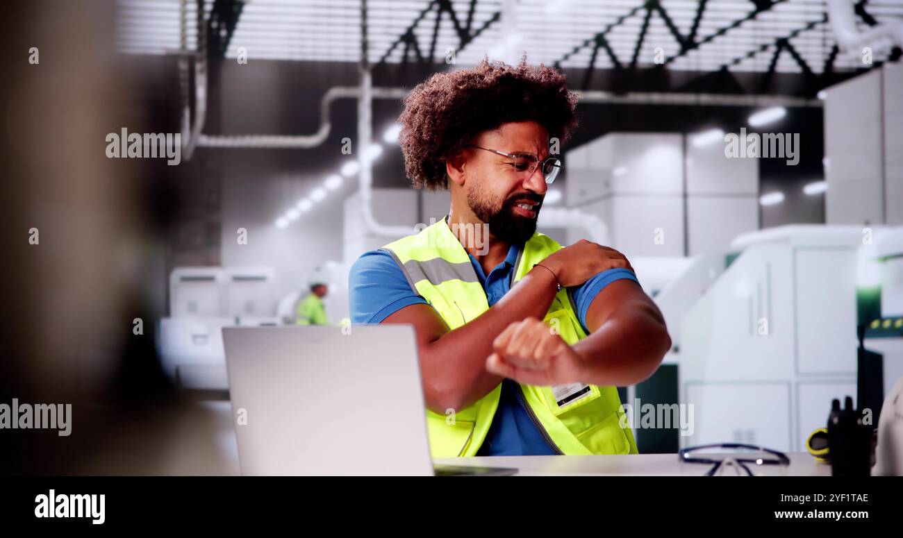African Man Doing Stretch Exercise At Automated Factory Or Plant Stock ...