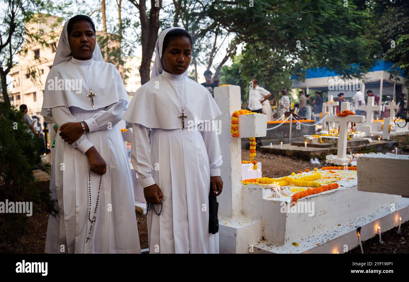 Nuns offer prayers on the grave during the All souls day observation ...