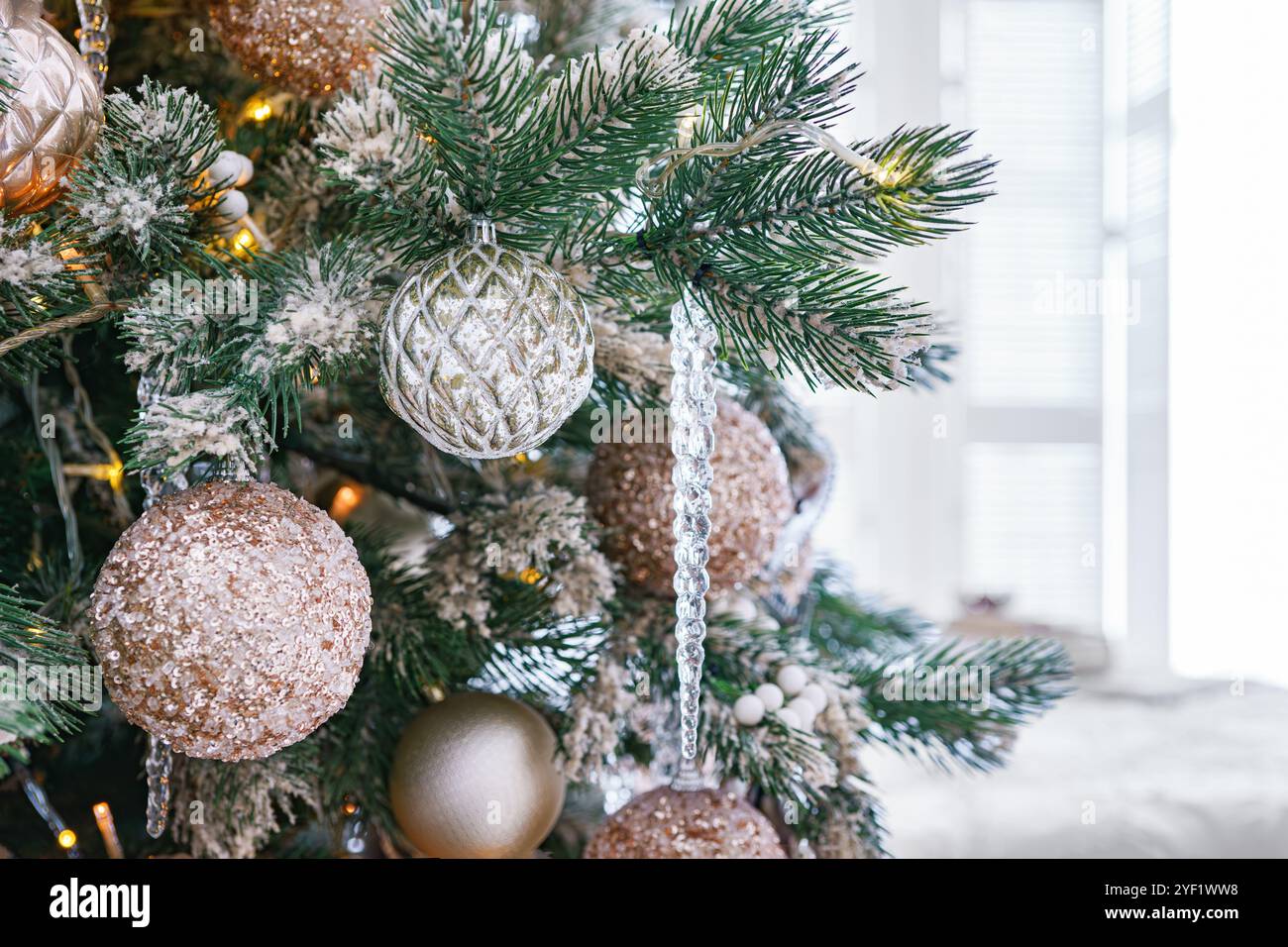 Christmas tree branch with frost decorated with shimmering ornaments ...