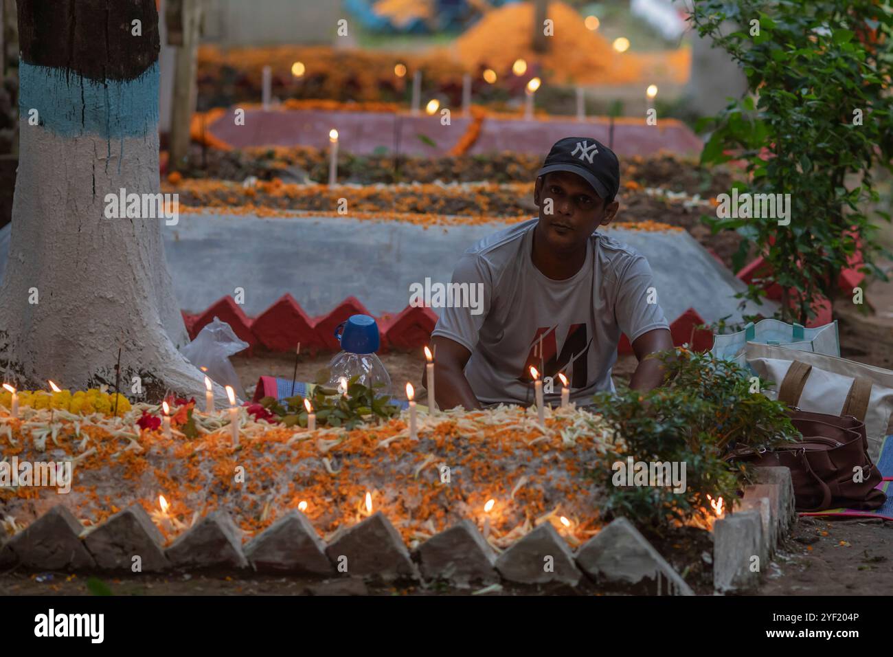 A boy lights candles in front the grave of his family member on the ...