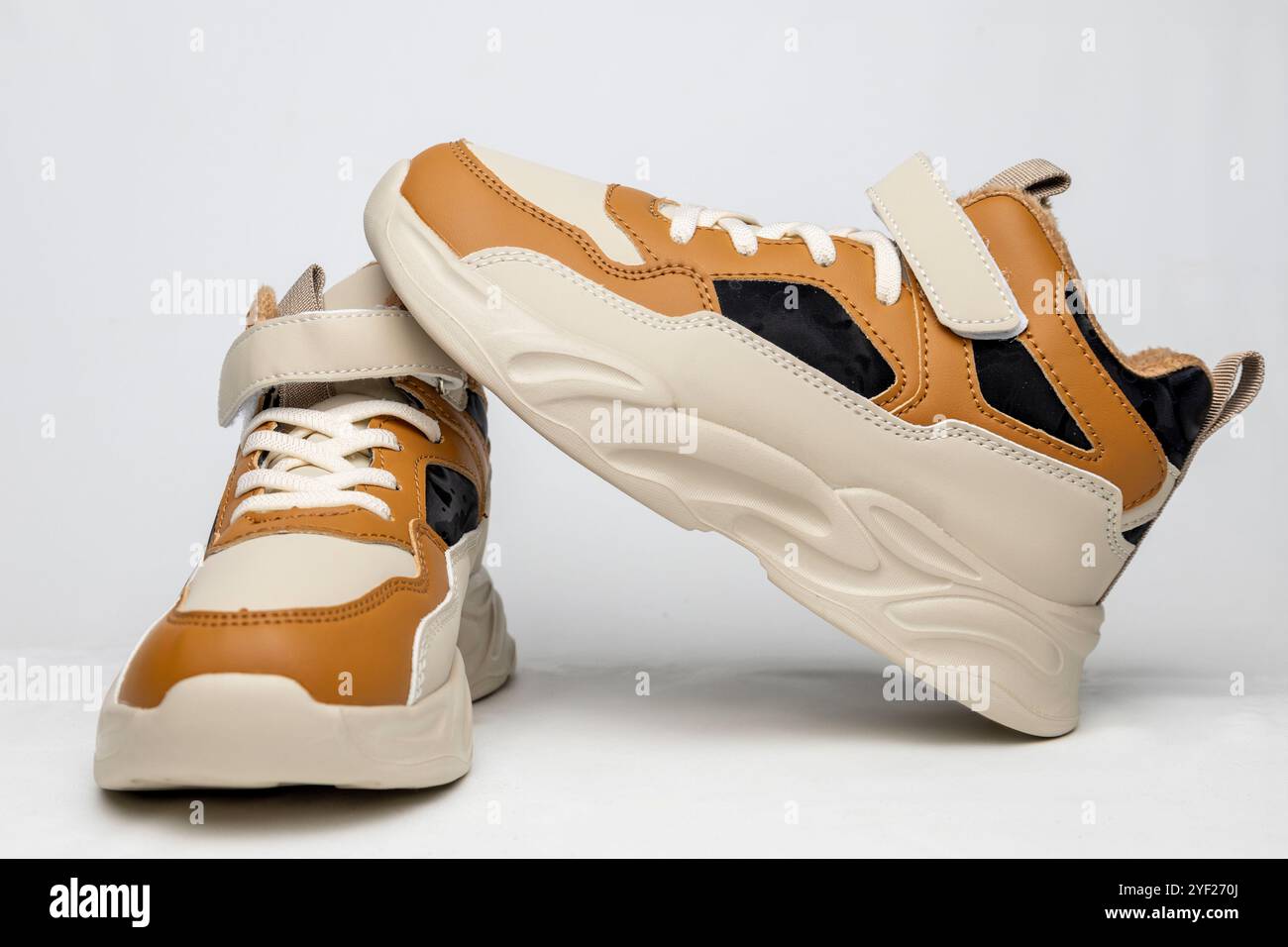 Stylish chunky sneakers featuring a beige and brown color scheme and a ...