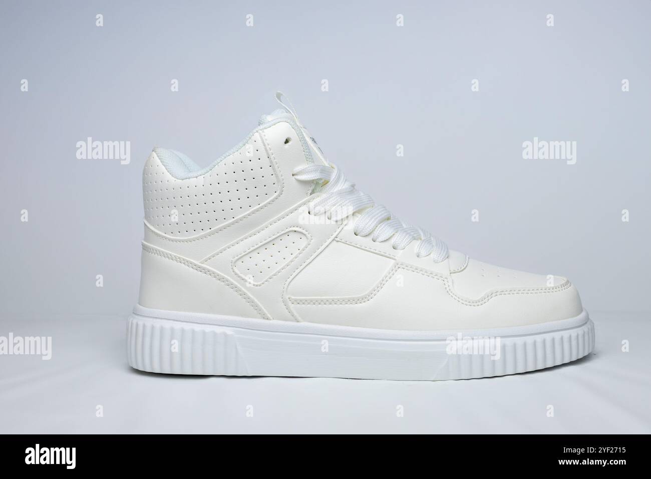 White sneaker standing on white background representing modern fashion ...
