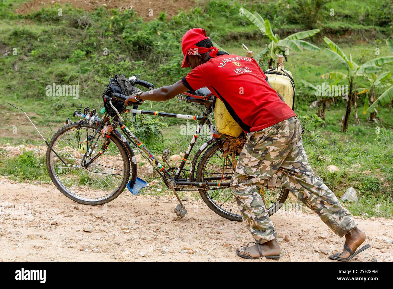 Man pushing a bike loaded with water tanks in western Rwanda Country ...