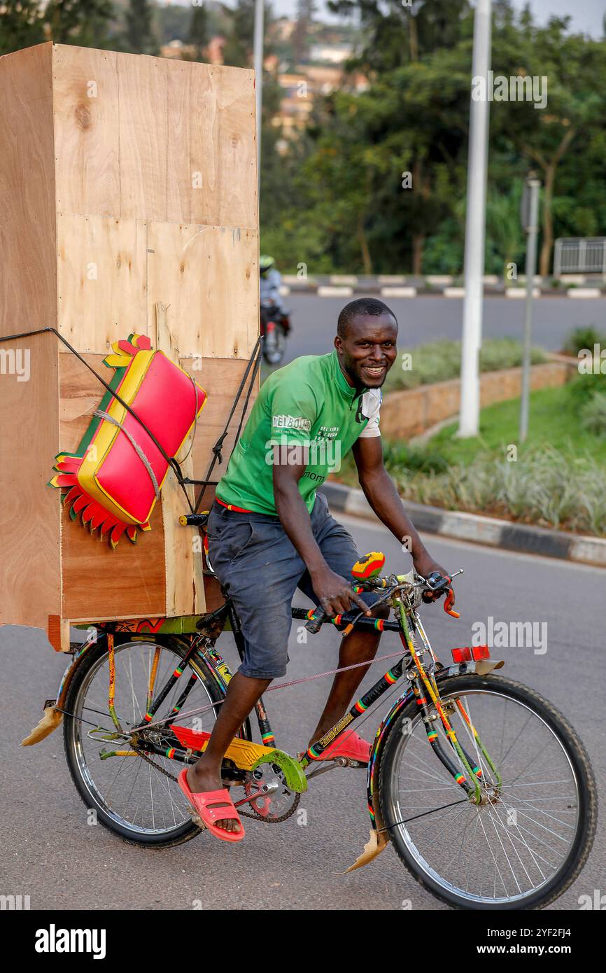 Man riding a bike loaded with a piece of furniture in Kigali, Rwanda ...