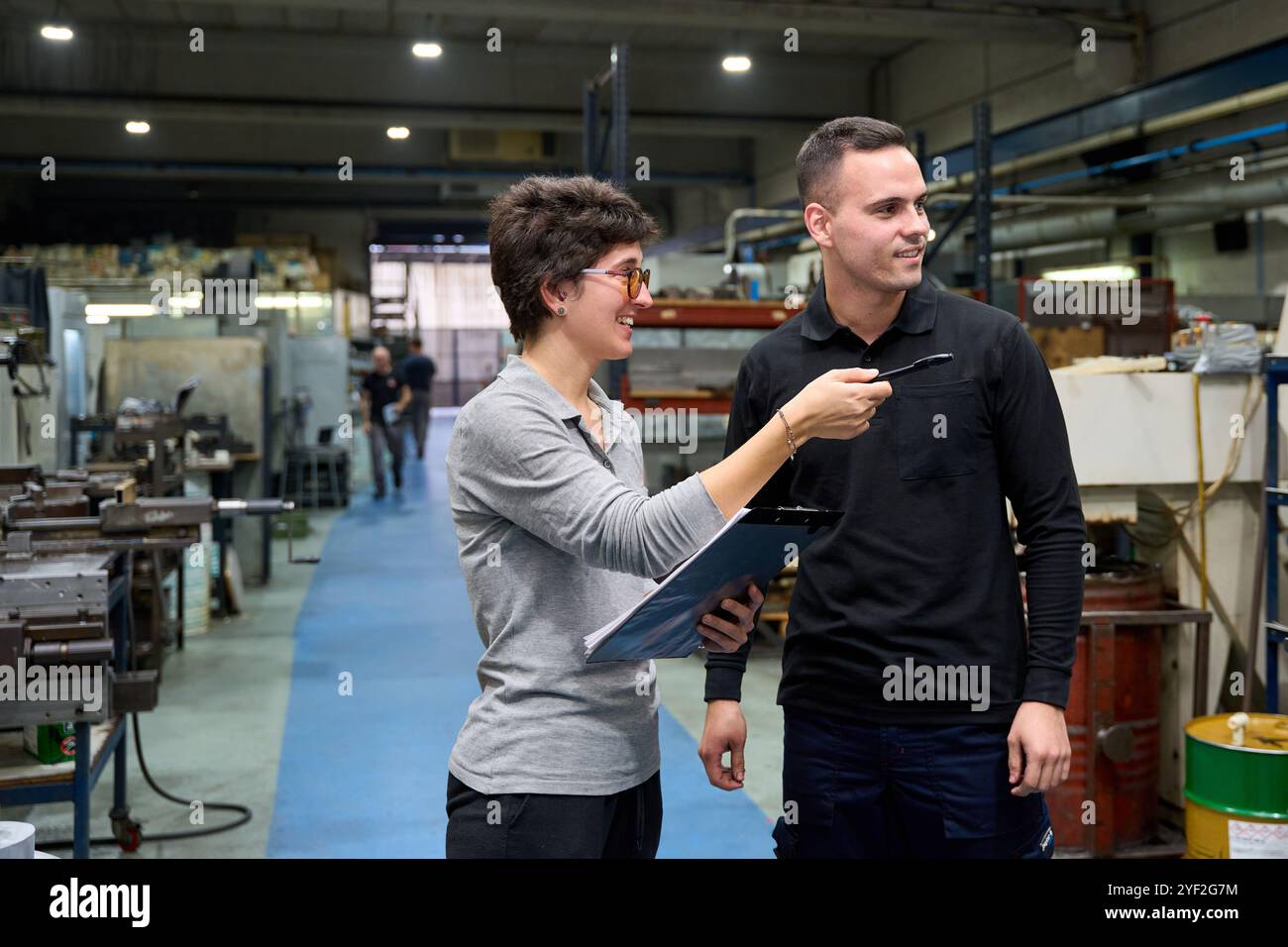 Metalworker using cordless drill in workshop creating custom mechanical ...