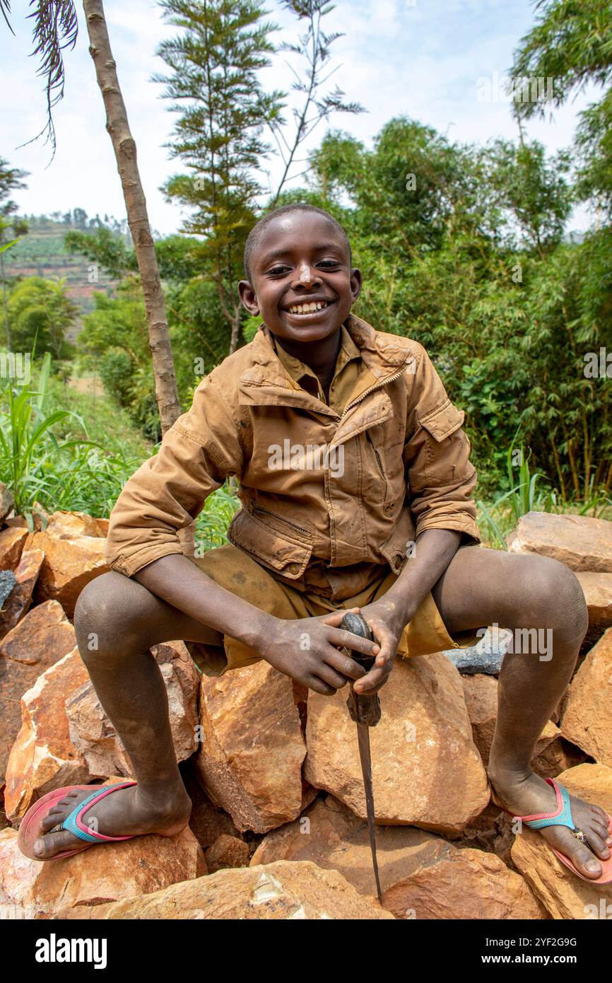 Smiling boy sitting on rocks, Cukiro Hill, Muhanga district, Rwanda ...