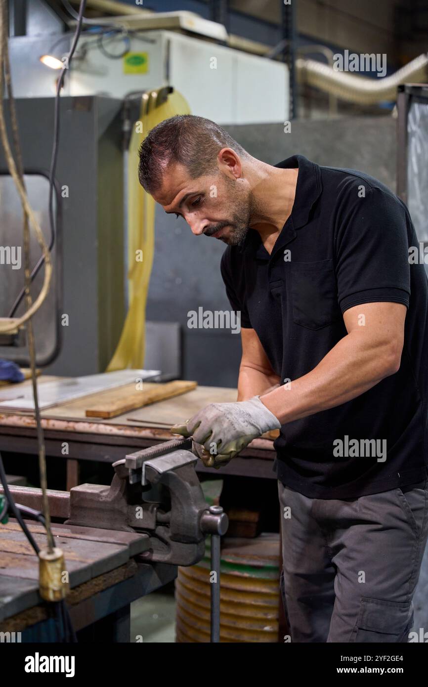 Metalworker operating cnc machine for custom mechanical parts ...