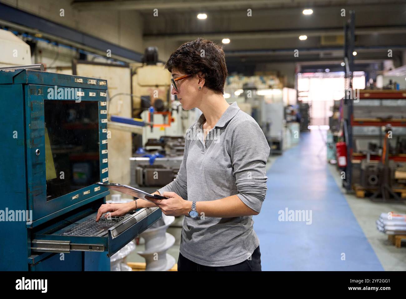 Two industrial workers discussing production process in a manufacturing ...