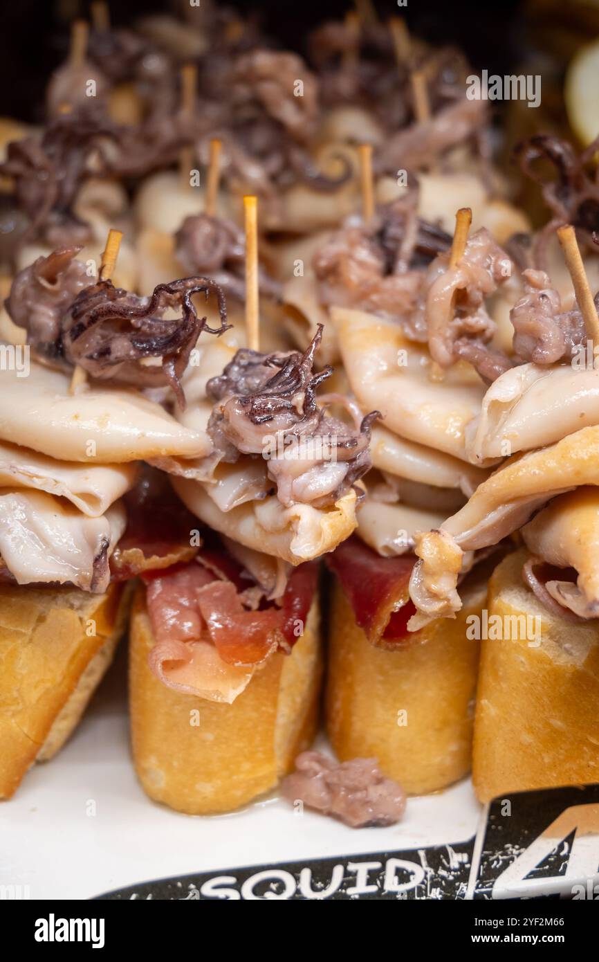 Typical snacks of Basque Country, pinchos or pinxtos skewers with small ...